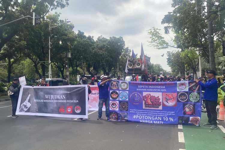 Foto : Bentangkan Spanduk, Massa Demo Ojol Bergerak ke Patung Kuda